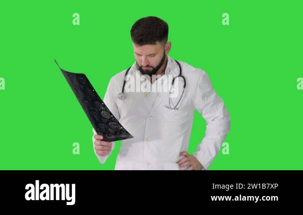 Doctor from middle east walking and looking at ct scan on a Green ...