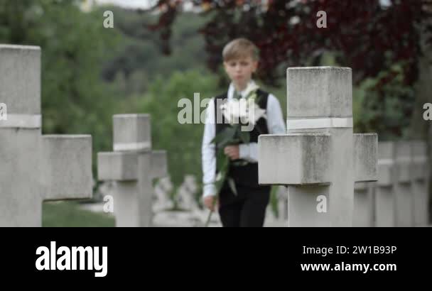 Teenager boy coming to honour his perished father at cemetery. Young ...