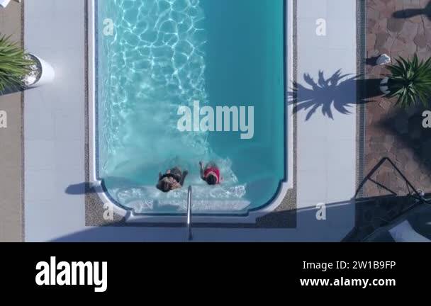 drone view on long-haired girlfriends into bathing suit are floating in ...