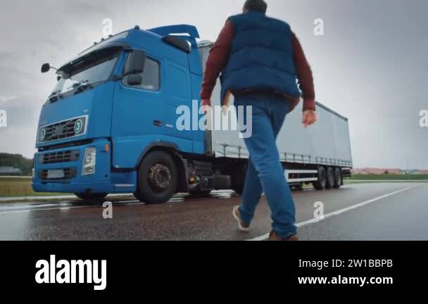 Truck Driver Crosses the Road in the Rural Area and Gets into His Blue ...