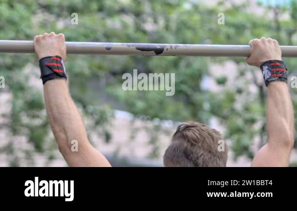Back Shot of a Fit Man Hanging on a Monkey Bar while Flexing His Back ...