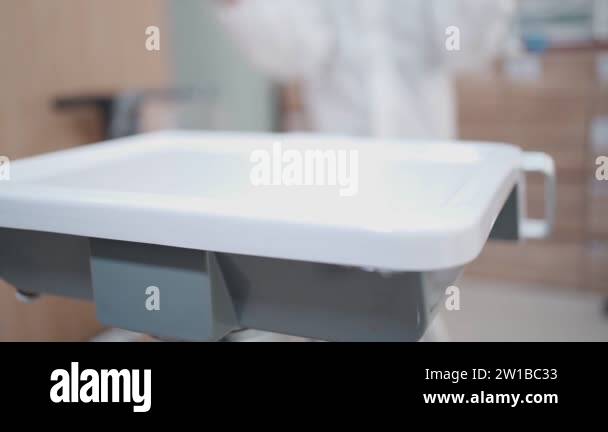 Medical nurse staff in white PPE suit wrapping dental equipment desk ...