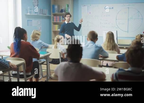 Caring Teacher Explains Lesson to a Classroom Full of Diverse Children ...