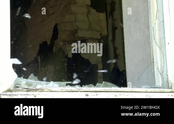 Soldier in military uniform with guns is firing from window of ruined ...
