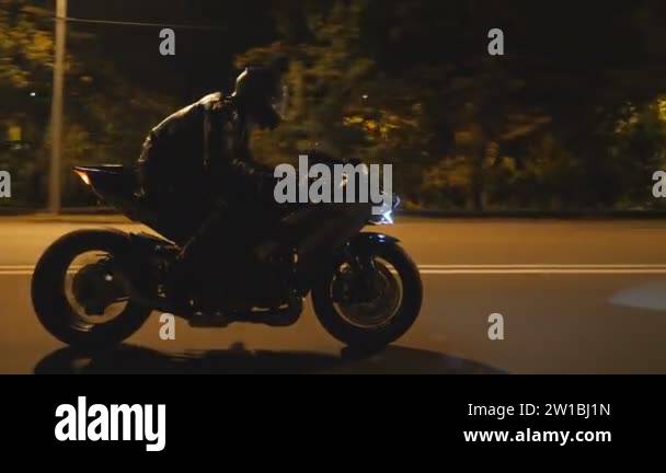 Man riding fast on modern black sport motorbike at evening city street ...