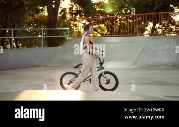 Attractive stylish girl with dreadlocks walks with bmx bike in ...