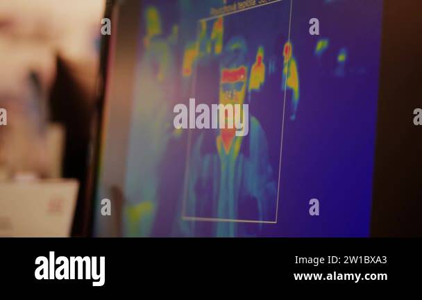 Suspicious person in glasses on display of infrared thermometer heat ...