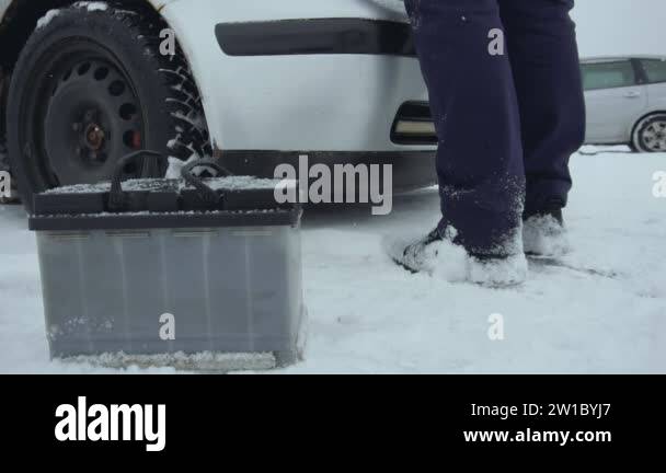 Man repairs or fixes broken car in winter snowfall. Malfunction or ...