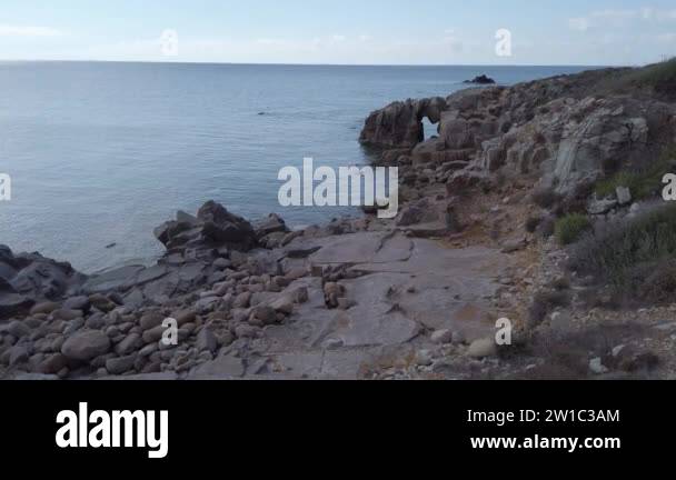 Awesome seascape from the cliff to rocky bay with natural cave ...