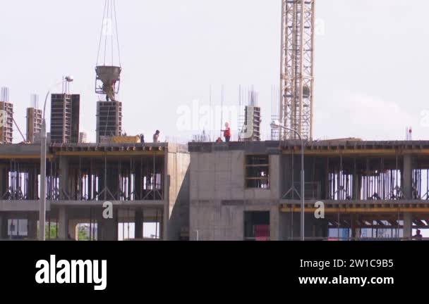 Builders on the construction site erect a monolithic building ...