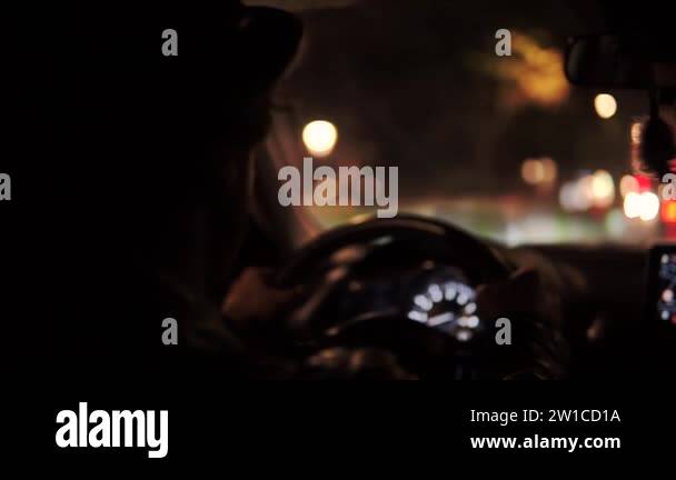 Stylish Man in hat driving a Car in Paris at Night, with brurred night ...