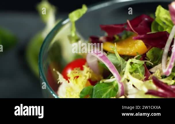 Closeup of super slow motion of falling fresh salad with camera motion ...