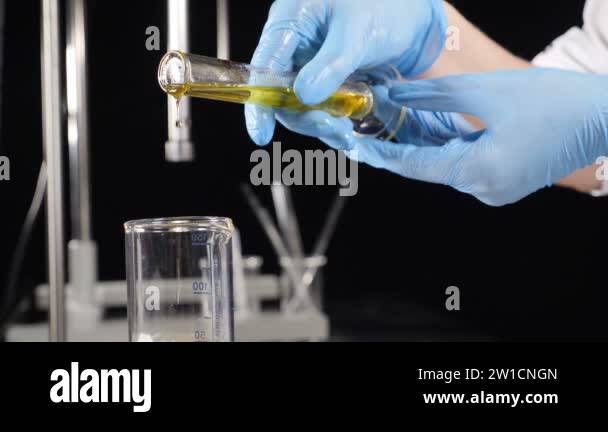 Production of cosmetics in small private lab. Gloved hand pouring ...
