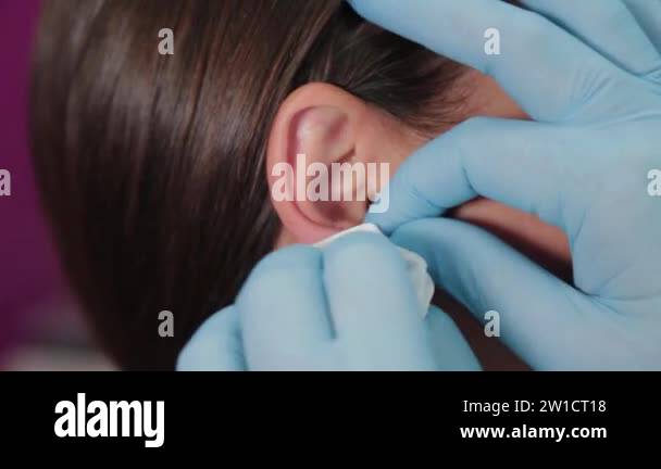Doctor woman conducts ear piercing procedure for client Stock Video ...