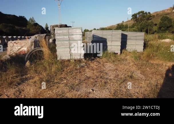 Building materials in packages, pallets stored in field at construction ...