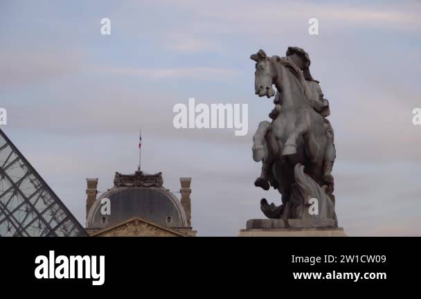 Monument to Louis XIV, Louvre Museum. Flag of France and the pyramid of ...