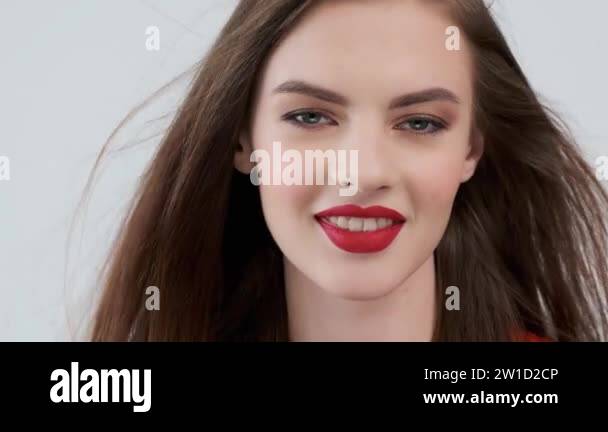 Closeup face of a beautiful smiling happy woman looks at camera ...