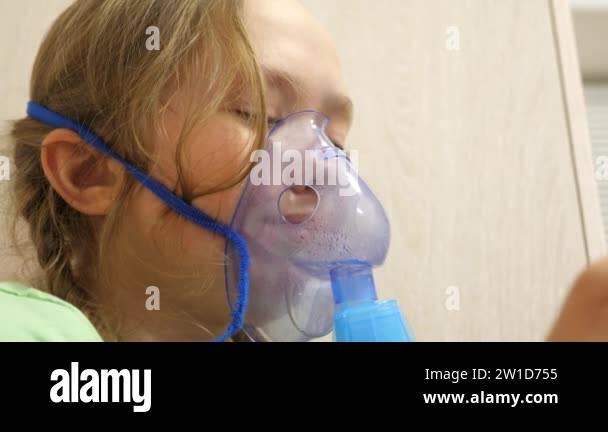 child with tablet is sick and breathes through an inhaler. close-up ...