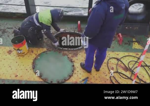 mechanics change pins of cargo tank hatch on oil tanker Stock Video ...