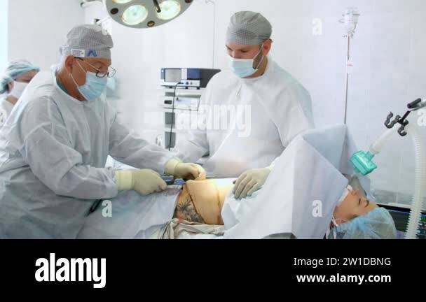 abdominal liposuction, surgery in actual operating room. surgeon pumps ...