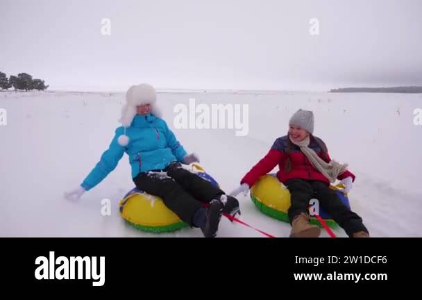 children and mom ride sledding in winter. mother and daughter play on ...