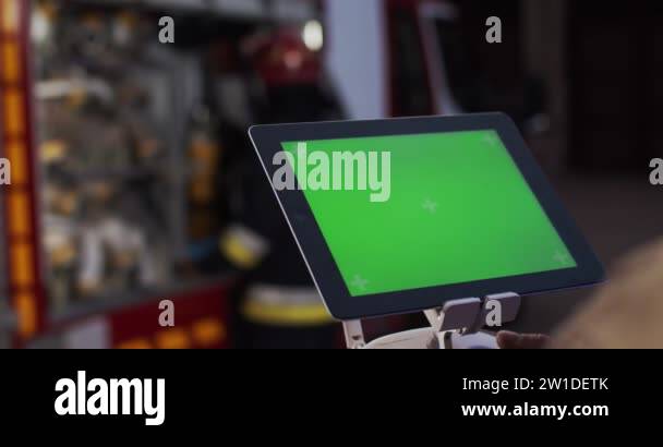 Close up of firefighter looks at scale of fire using a screen broadcast ...