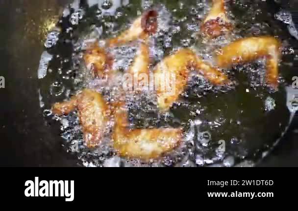 Chicken deep fry in hot oil close up in a Chinese restaurant. Progress ...
