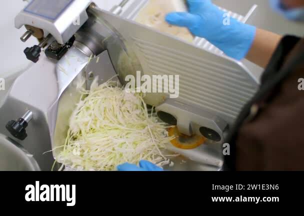 cooking. close-up. cuisine worker, in protective gloves, cuts fresh ...
