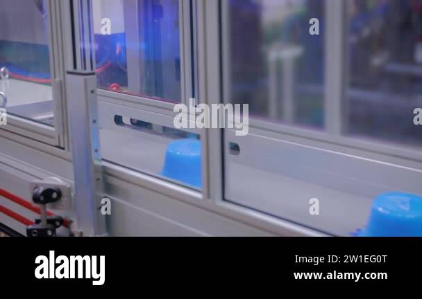Blue pots on conveyor belt of plastic injection molding machine with ...