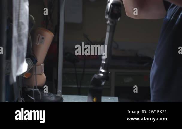 Production of a prosthetic leg. A man creates part of the leg. An ...