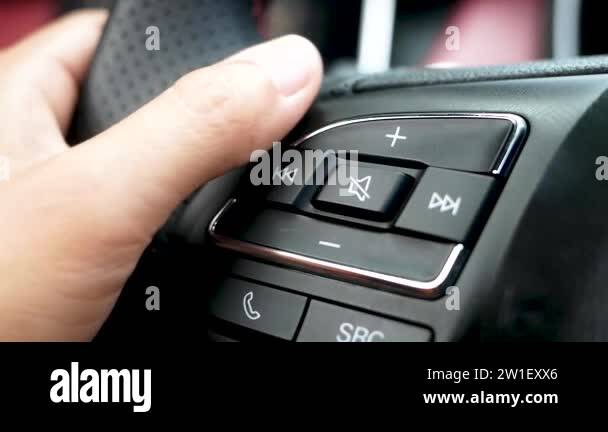 Close up of finger pressing the audio control buttons to increase or decrease the volume on the ...