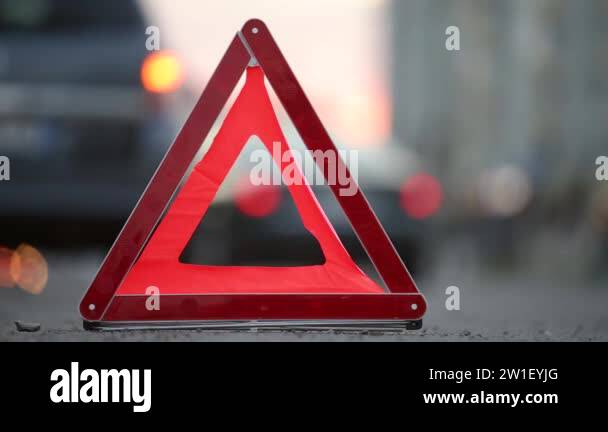Red emergency stop sign behind broken blurred car with blinking lights ...