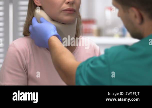 Traumatologist examination of female patient with foam cervical collar ...