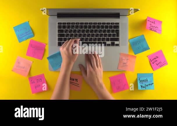 Using laptop typing hands, post it papers on work place, remind ...