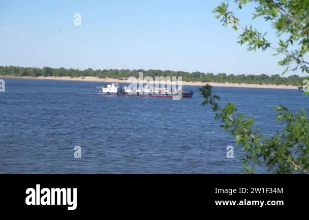 small ship tanker moves on calm water through the sea strait. a small ...