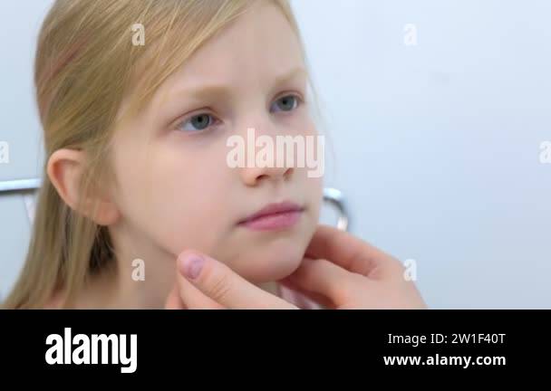 Pediatrician woman probing lymph nodes on neck of girl child during ...