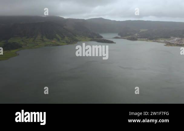 Lake in extinct volcano caldera with town on its shore. Aerial of ...