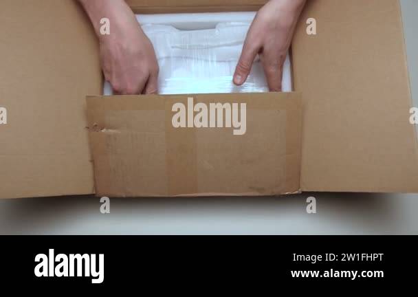 Unpacking the parcel. A man from a package takes out something white ...