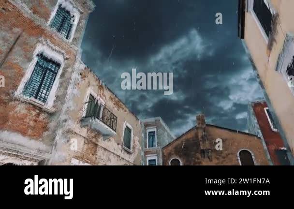 Looking up at ancient historic buildings against stormy sky background ...