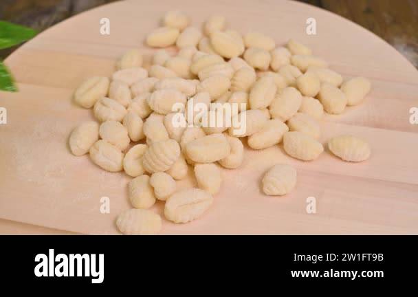 Raw uncooked potato gnocchi with flour and grated parmesan cheese over ...