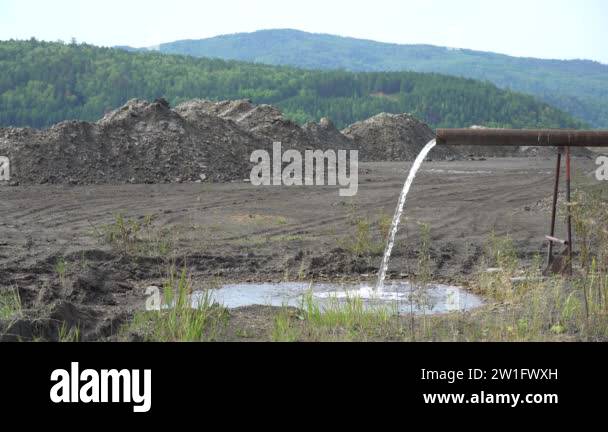 Waste water discharge and heaps of ash and slag waste at ash dump of ...
