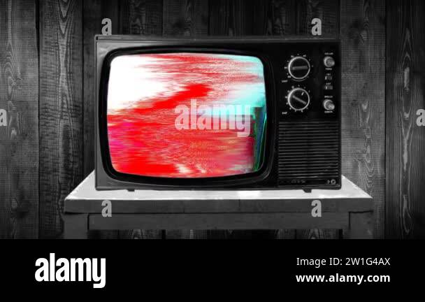 Zoom in then fixed shot on a archaic TV set, failed reception, glitch ...