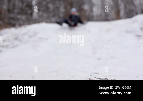Boy slides on sled by slope Stock Video Footage - Alamy