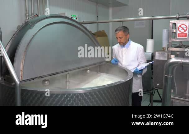 Dairy Plant Technologist With Clipboard Checking Milk Pasteurization Process. Milk ...