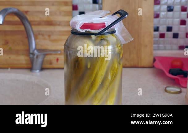 Close-up jars of ripe pickles and unripe pickles are standing side by ...
