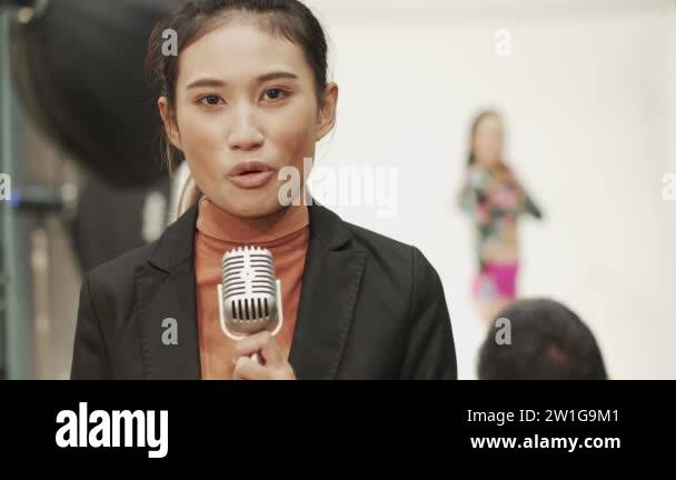 20s Asian Woman News Reporter hold microphone look at camera, wear ...