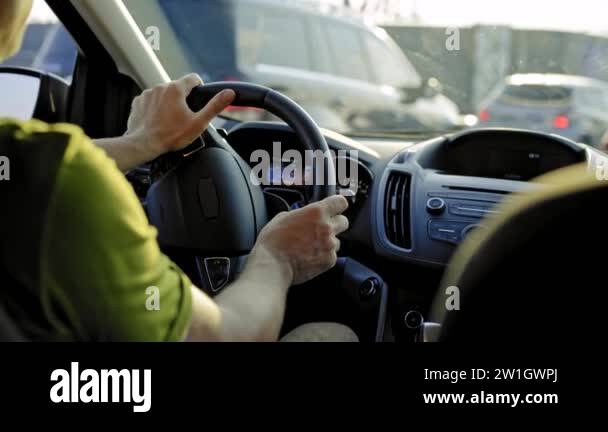 Man driving a car in traffic during rush hour. Hes turning right ...