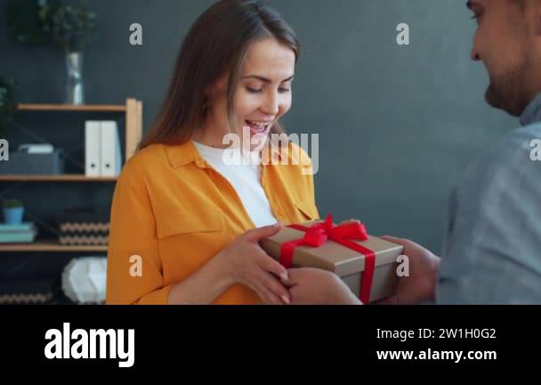Loving man congratulating woman giving gift box hugging expressing love ...