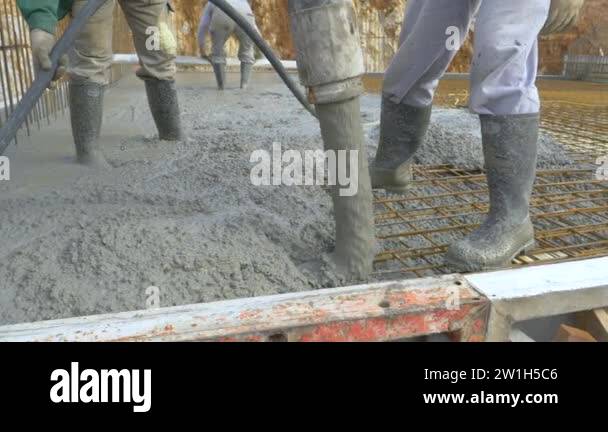 CLOSE UP: Fresh concrete flows out of a wide hose as contractors pour a slab Stock Video Footage ...