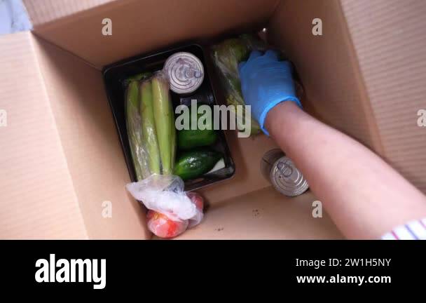 Door delivery of goods. Order picker packing foods in a cardboard boxes ...
